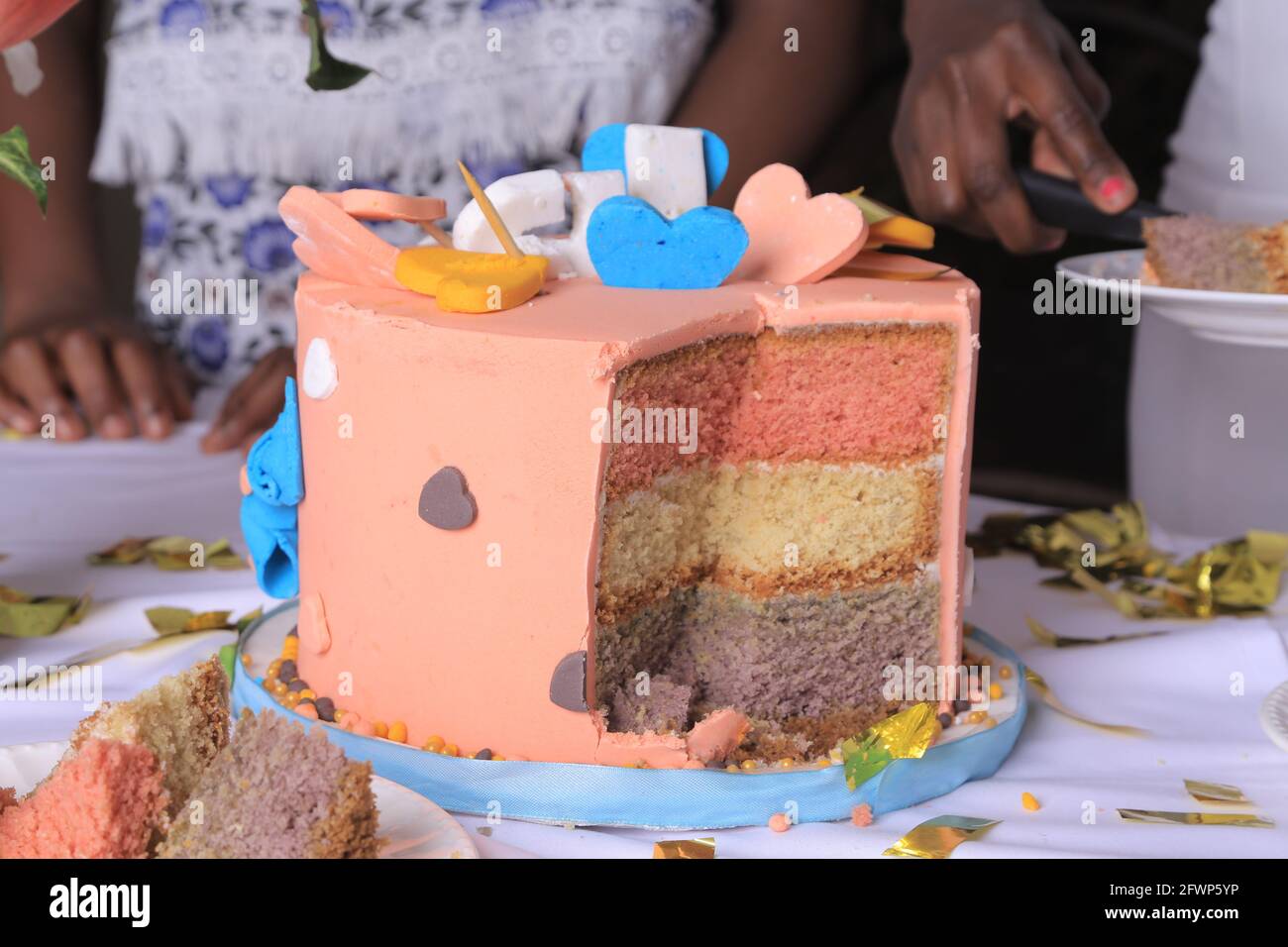 KAMPALA, UGANDA - Apr 20, 2021: Sliced birthday and party cake with ...