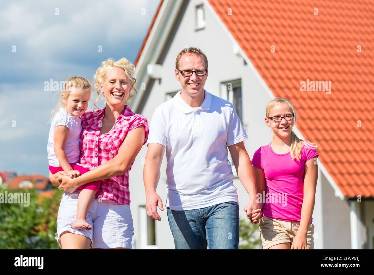 Family of Parents and children standing proud in front of home Stock ...