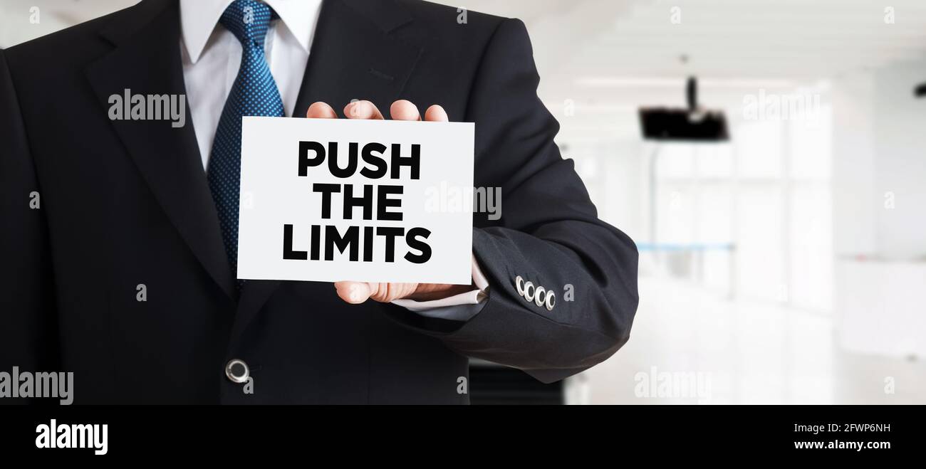 Businessman shows a business card with the message push the limits ...