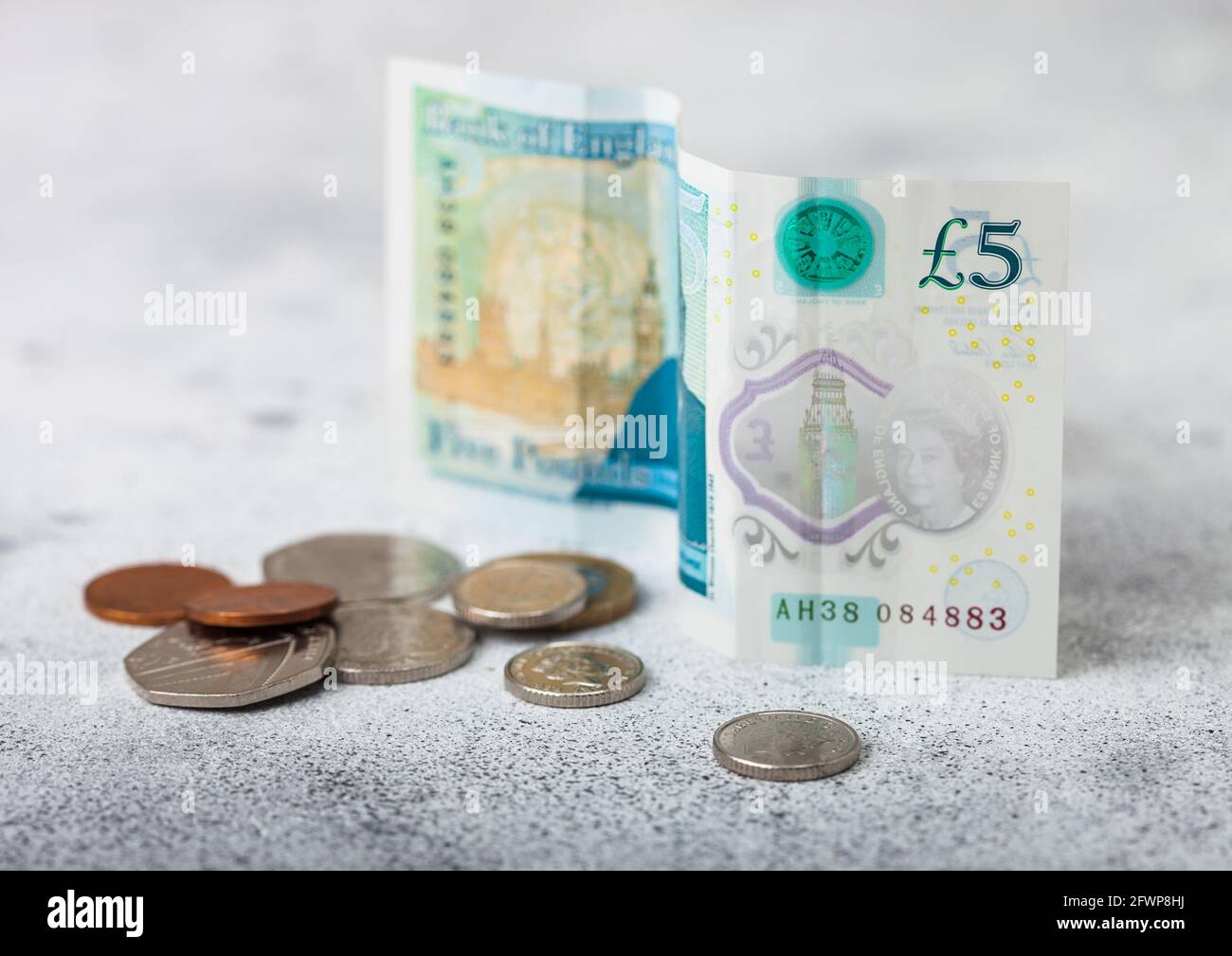 Five pounds banknote with coins on light background. World economy ...