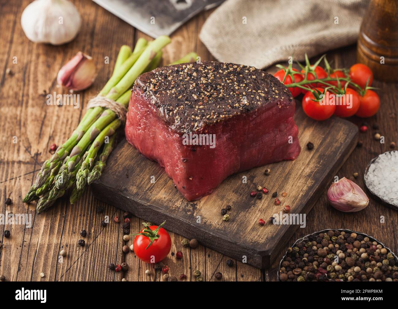 Slice of Raw Beef Topside Joint with Salt and Pepper on wooden chopping ...