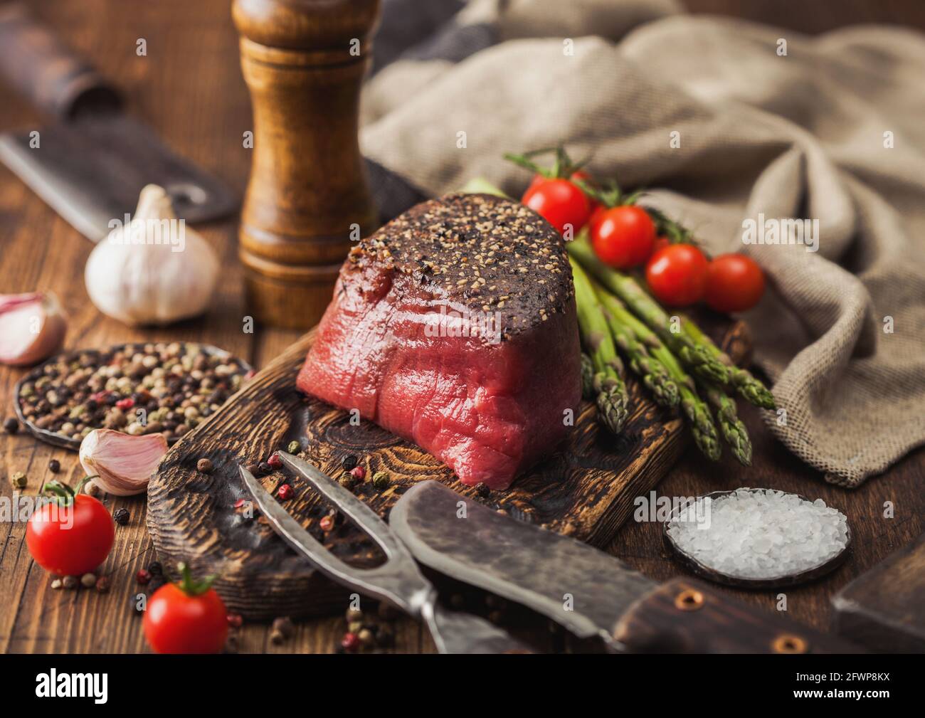 Slice of Raw Beef Topside Joint with Salt and Pepper on wooden chopping ...