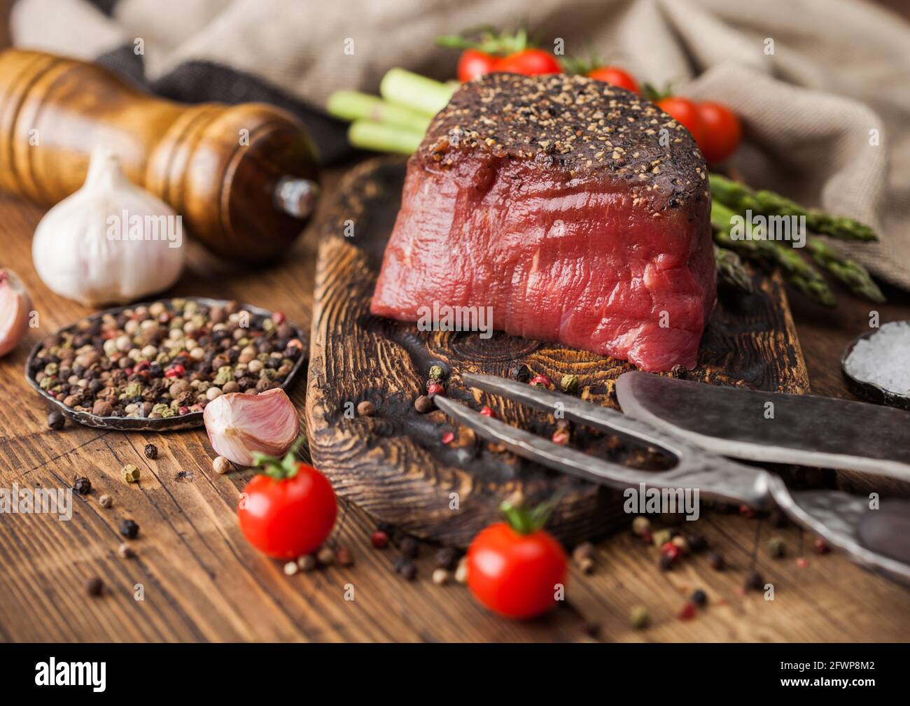 Slice of Raw Beef Topside Joint with Salt and Pepper on wooden chopping ...
