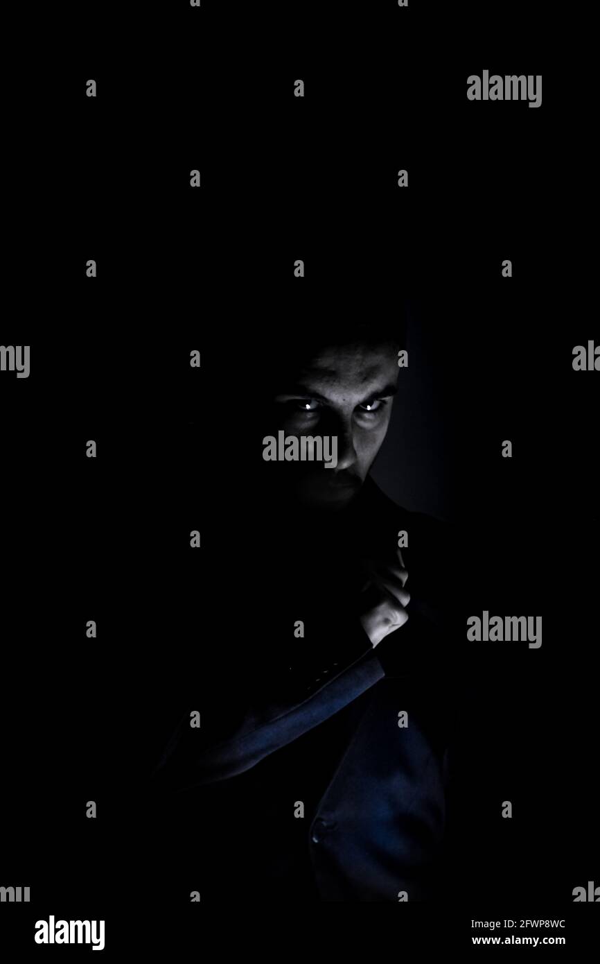 Vertical dark dramatic shot of a male with a serious expression Stock ...