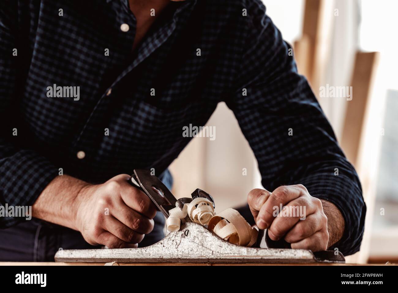 Carpenter's hands planing a plank of wood with a hand plane Stock Photo ...