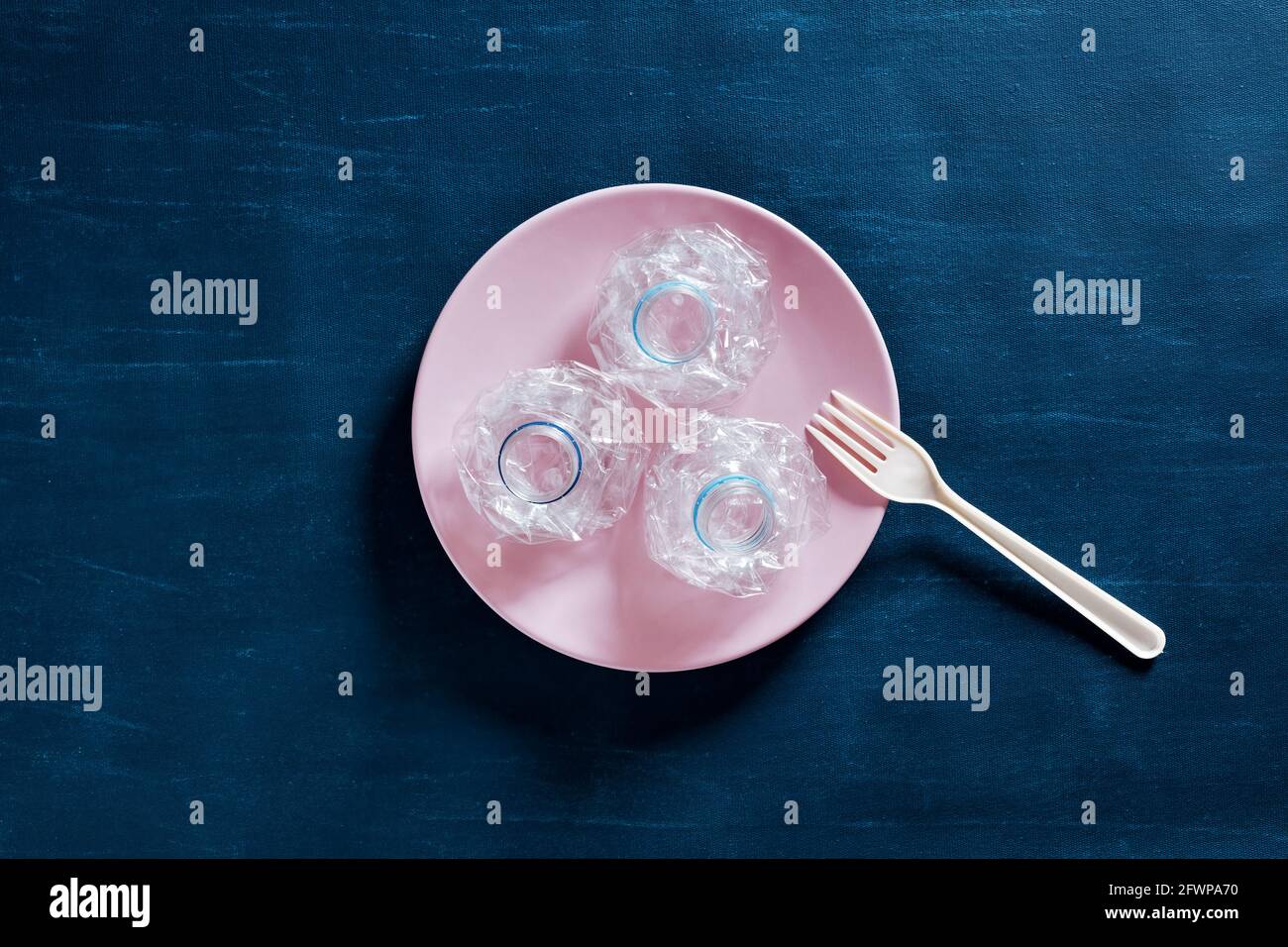 Pressed plastic water bottles on a plate with a plastic fork ...