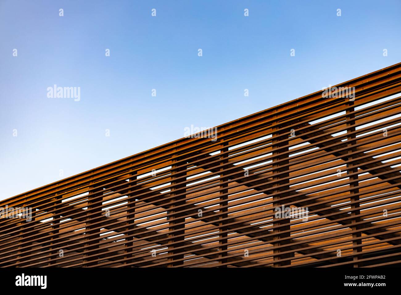 Wooden slat shading structure with roof against sky Stock Photo - Alamy