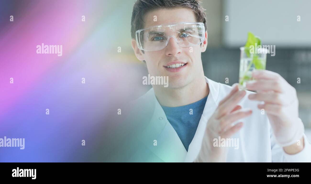 Composition of male scientist holding beaker with plant in laboratory ...