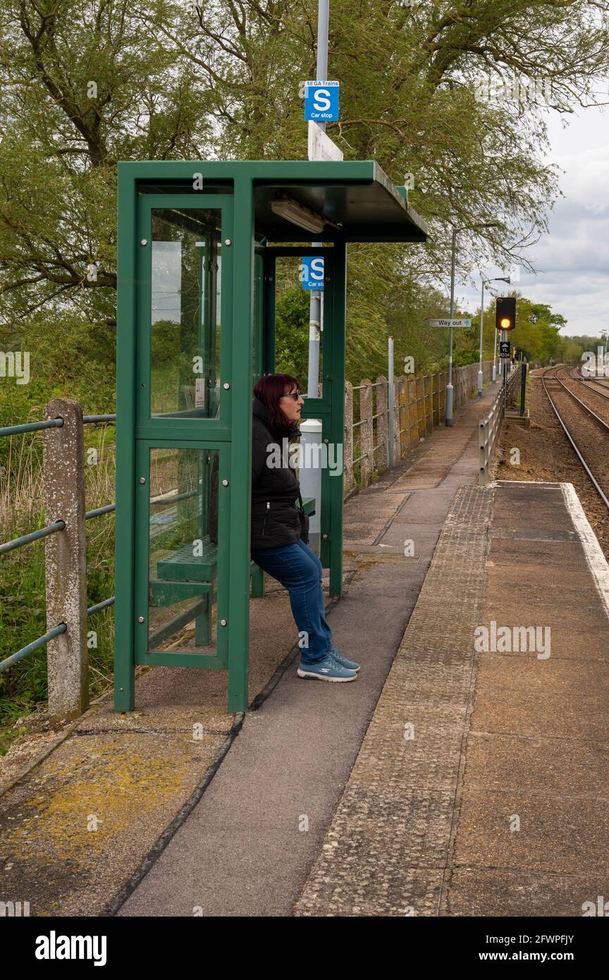 Women sitting in shelter waiting for train to arrive at Buckenham marsh ...