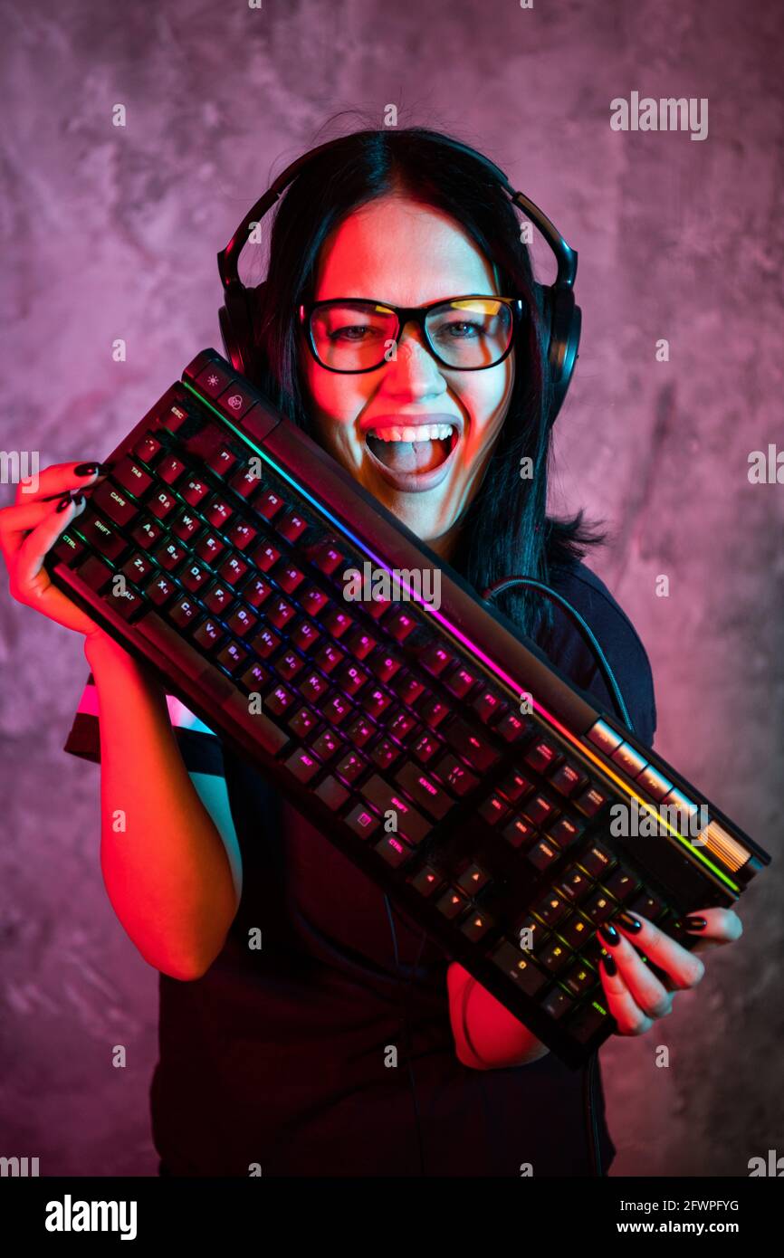 Nerd geek young adult women playing on the video console holding game ...