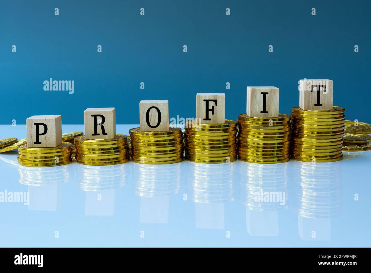 Profit text on wood block with a pile of gold coins Stock Photo - Alamy