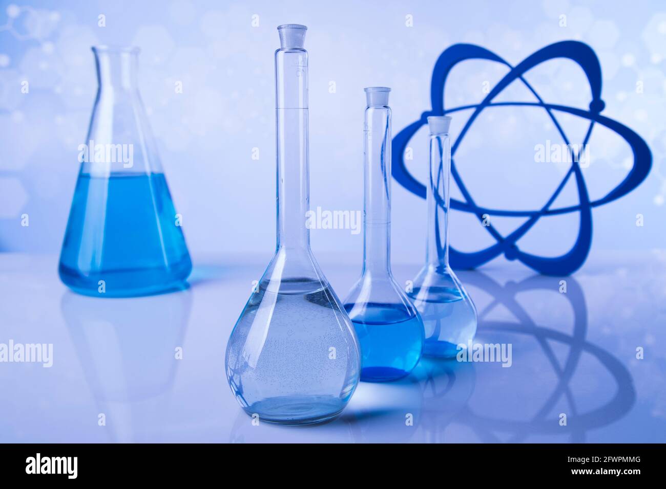 Atom, Laboratory beakers, microscope, blue background Stock Photo - Alamy