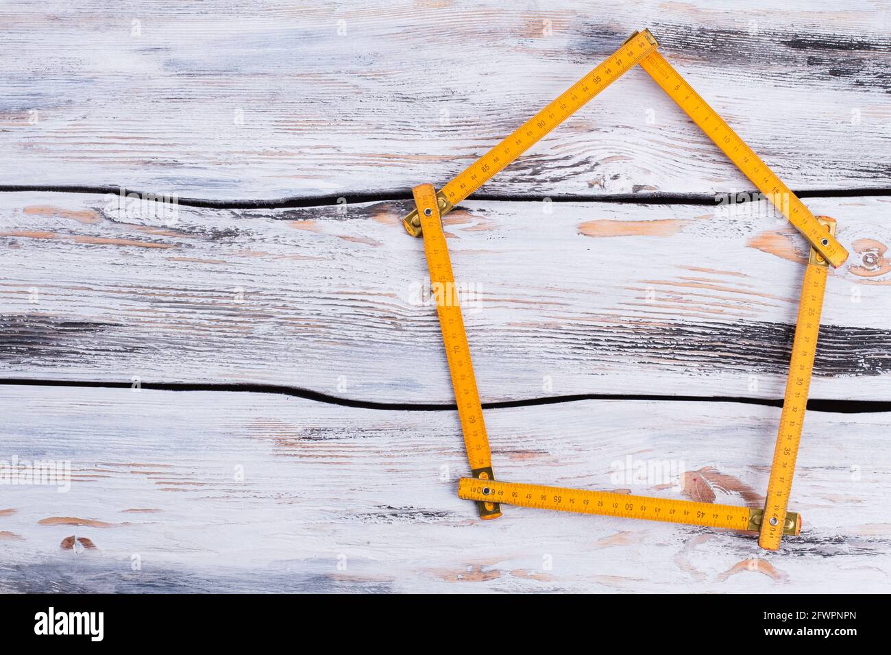 House-shaped yellow folding ruler. Construction, home building concept ...