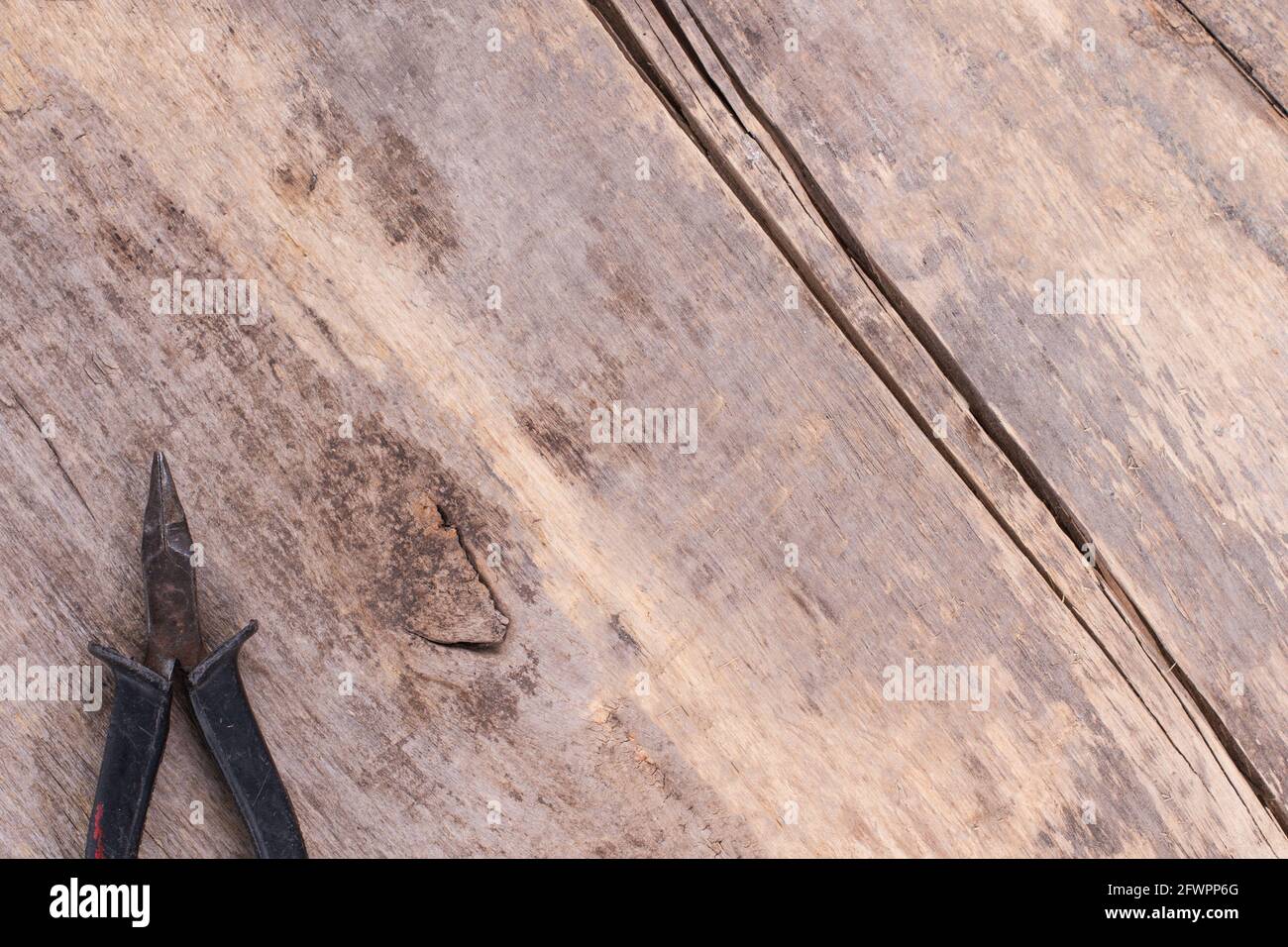 Old pliers with rubber handle on rustic wood Stock Photo - Alamy