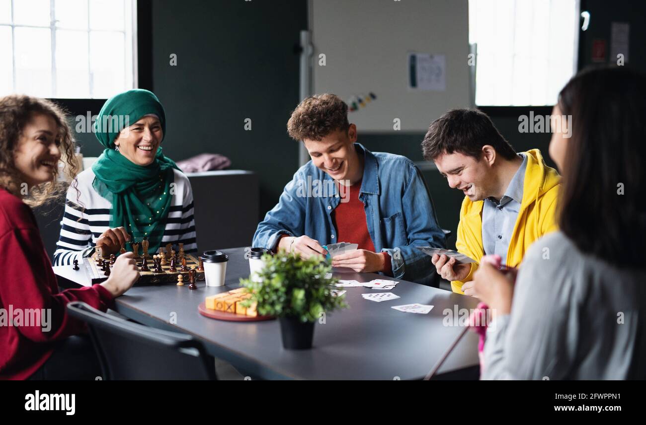 Group of people playing cards and board games in community center ...