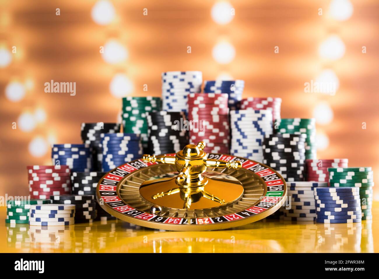 Poker Chips on gaming table, roulette wheel in motion, casino ...