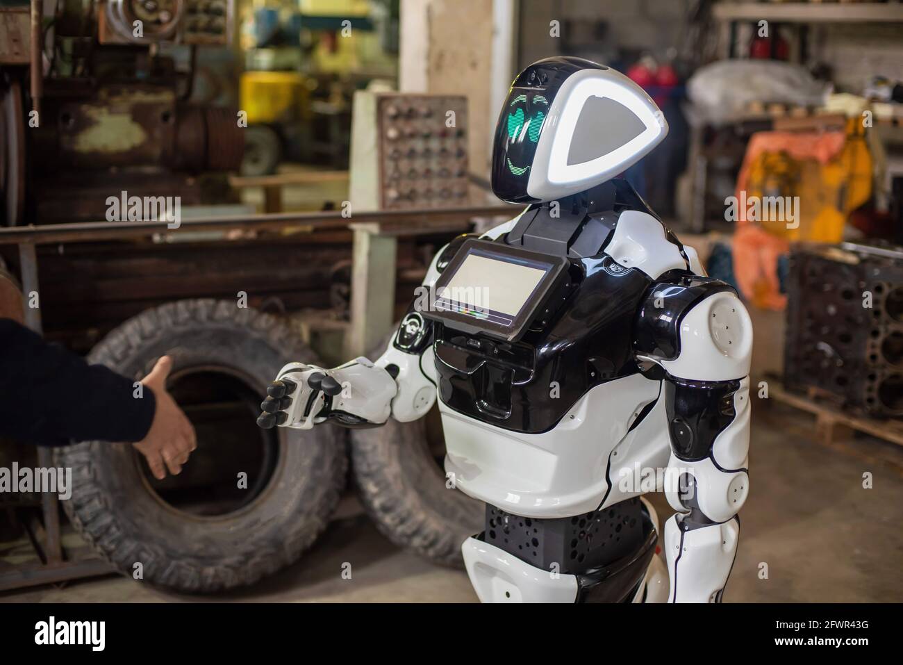 Humanoid robot on wheels with a monitor on his chest, shaking hands ...