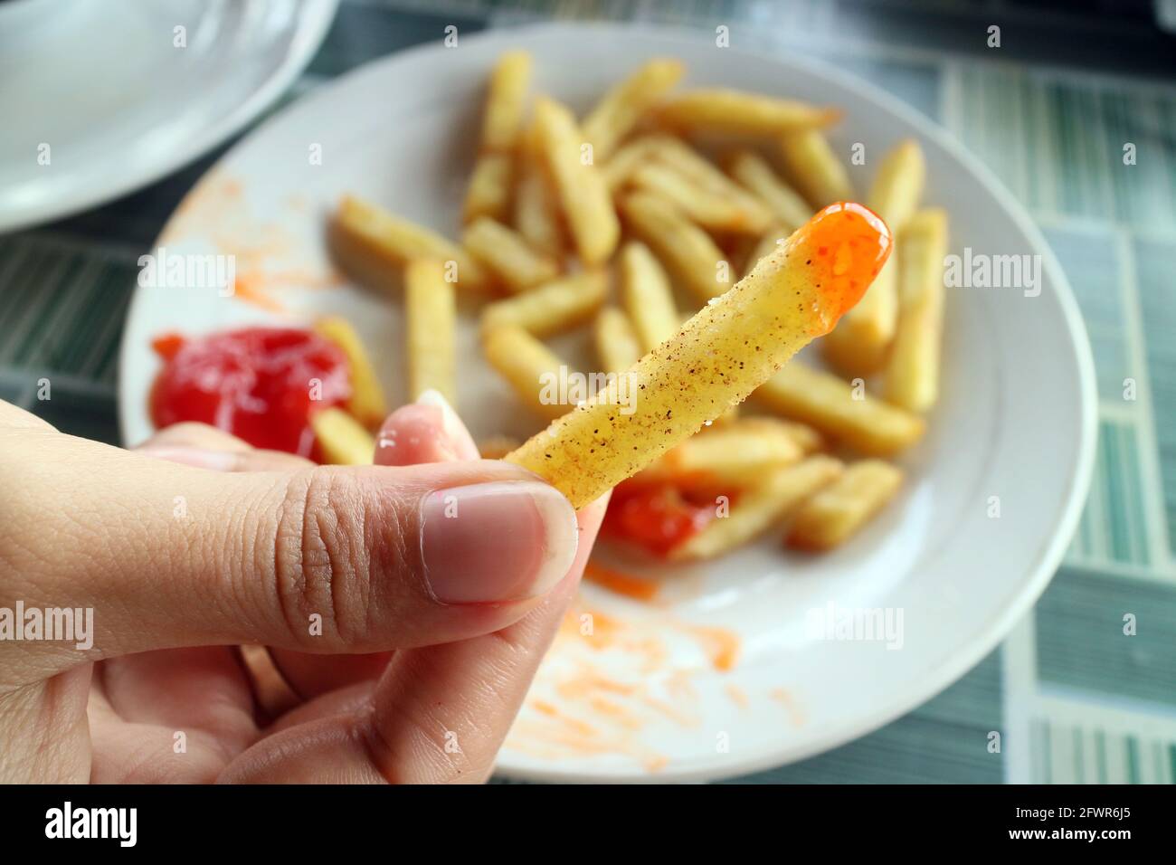 hand holding french fries with sauce photo Stock Photo - Alamy