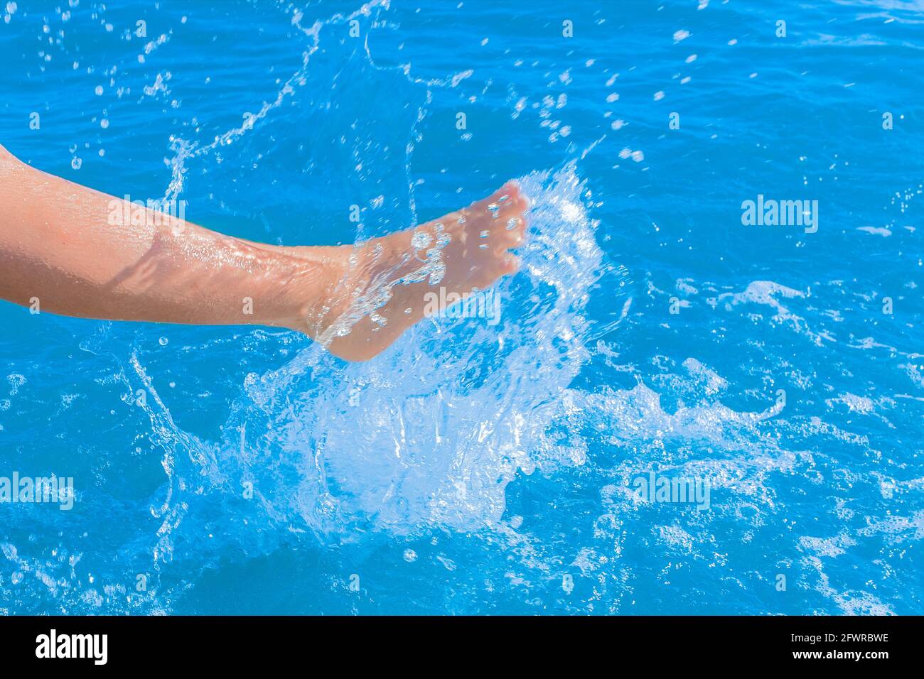 A young girl's leg sprays blue light sea water close-up Stock Photo - Alamy