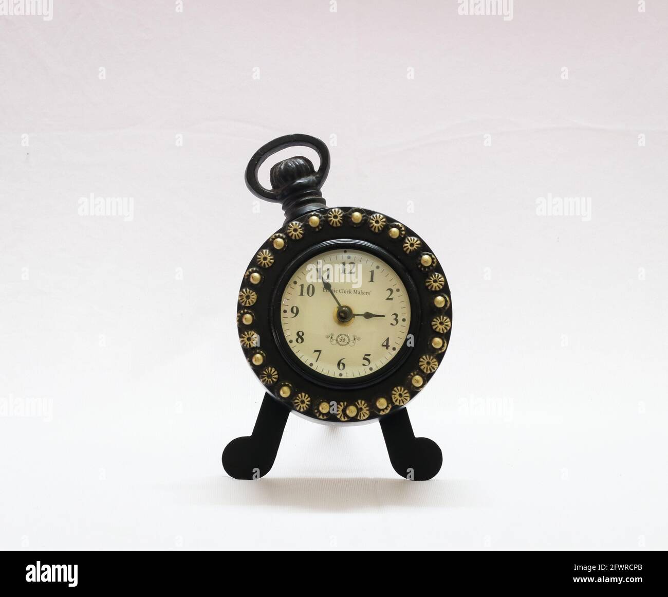 metallic analog antique clock with stand isolated in a white background ...