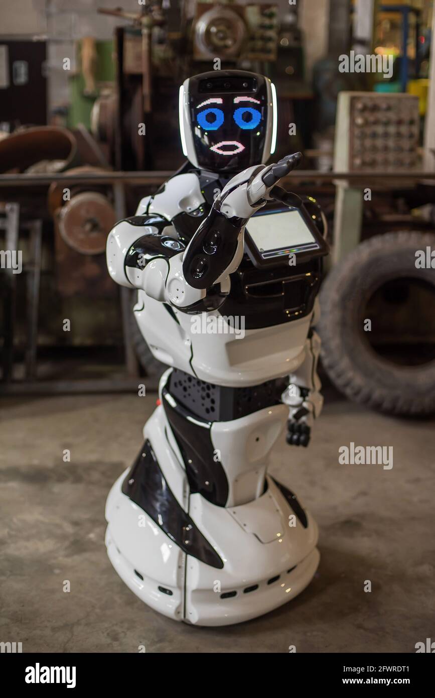 A humanoid, white robot on wheels, with a display on his chest, moves ...