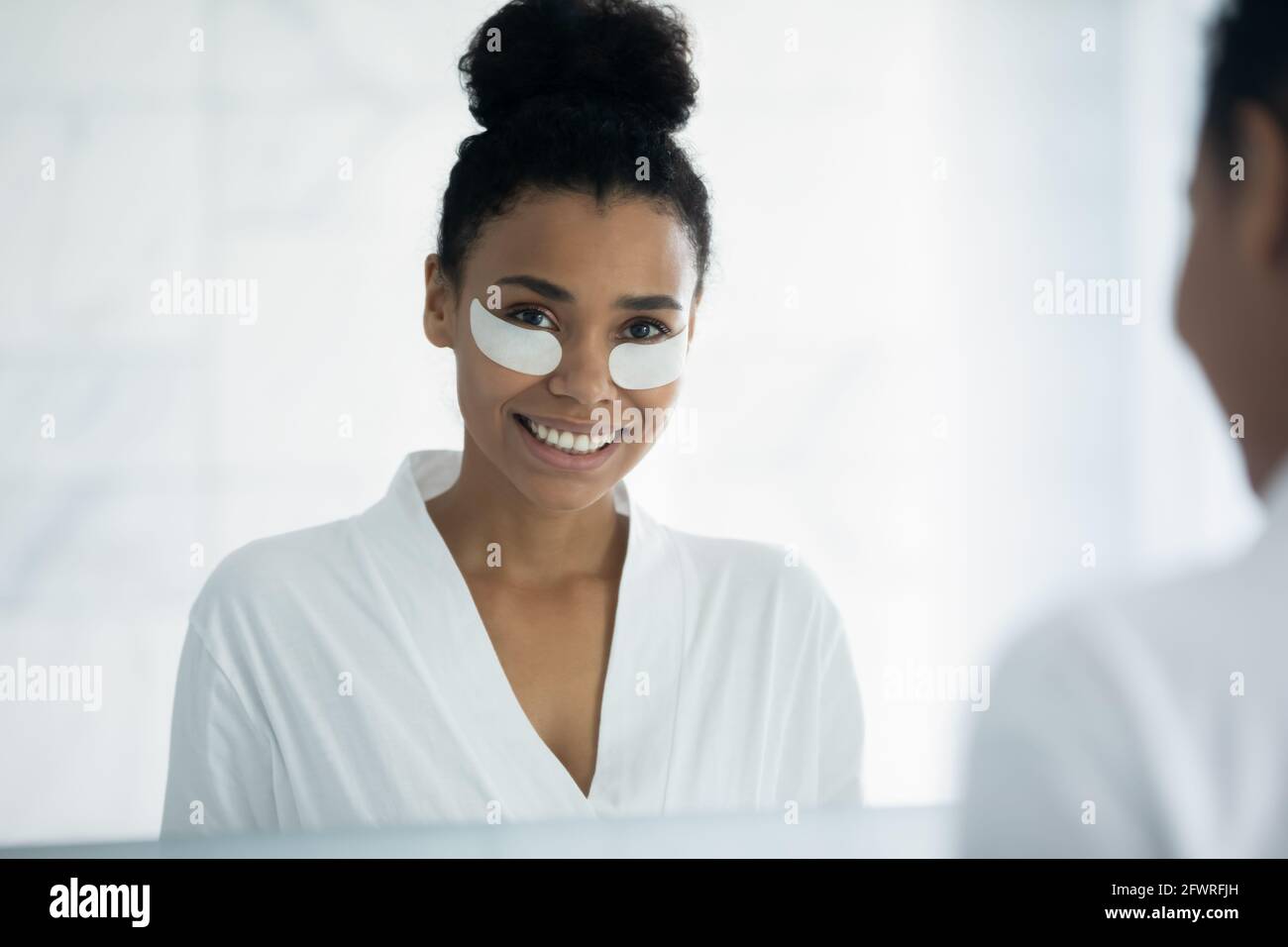 Smiling young Black woman with skincare under-eye collagen patches ... Smiling young Black woman with skincare under-eye collagen patches ...