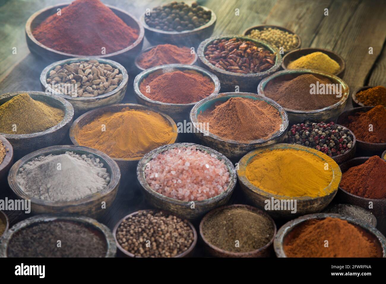 Wooden table of colorful spices Stock Photo - Alamy