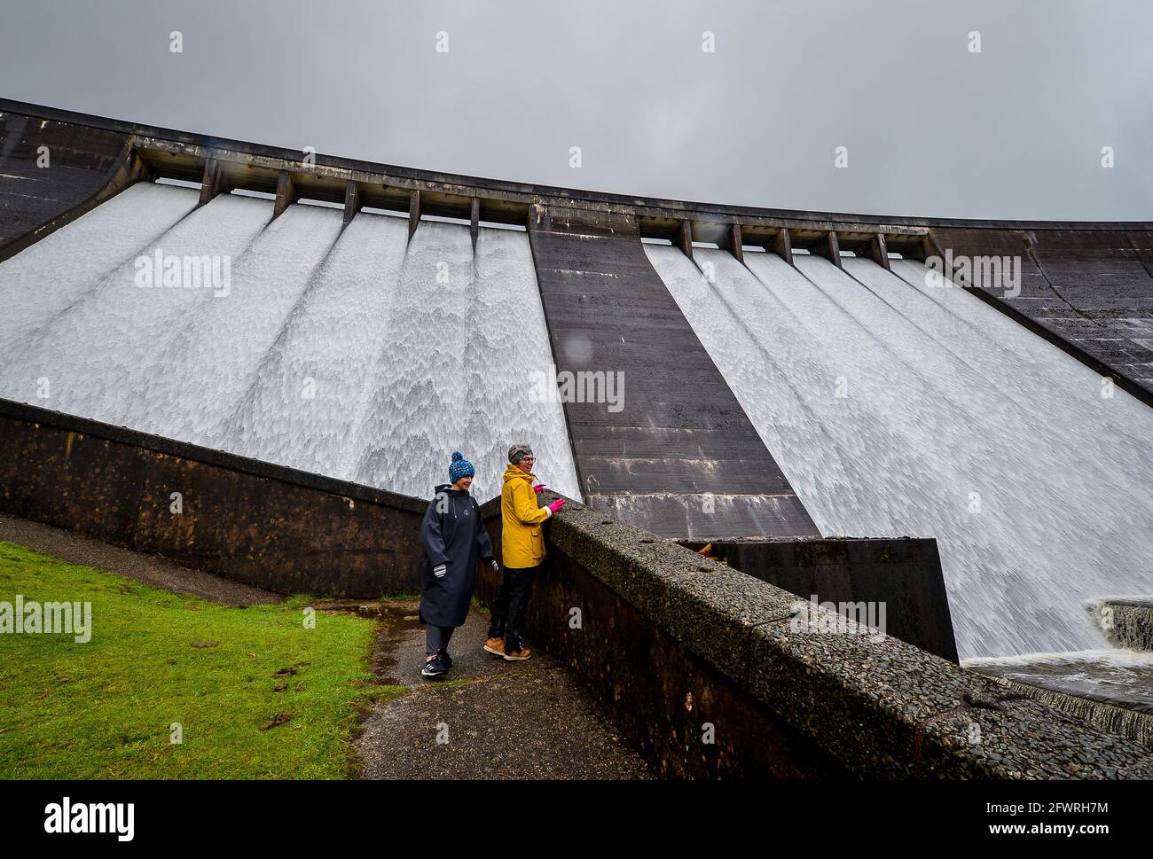 People look at the overflowing spillway at Meldon Dam in Dartmoor ...