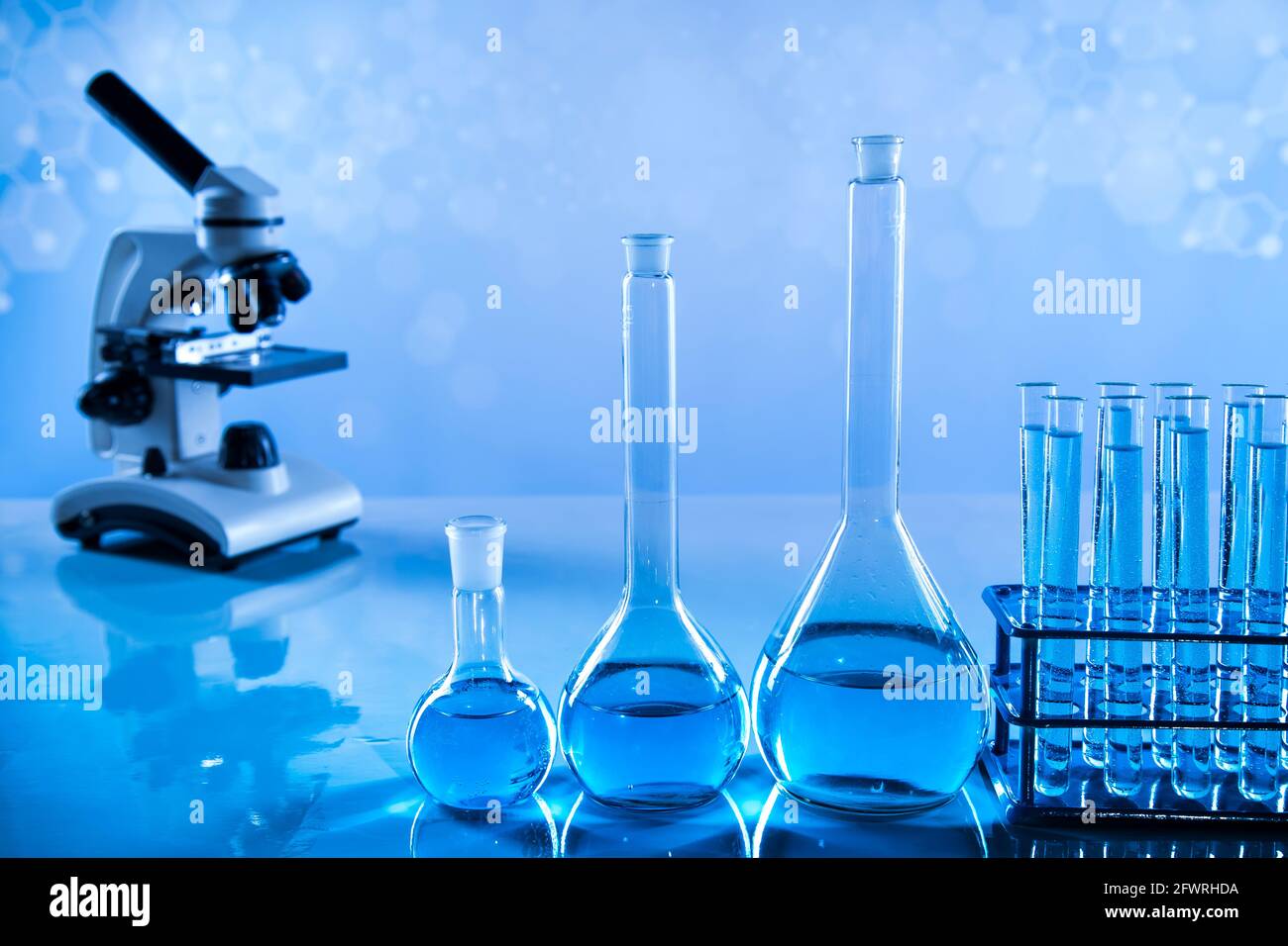 Laboratory beakers, microscope, blue background Stock Photo - Alamy