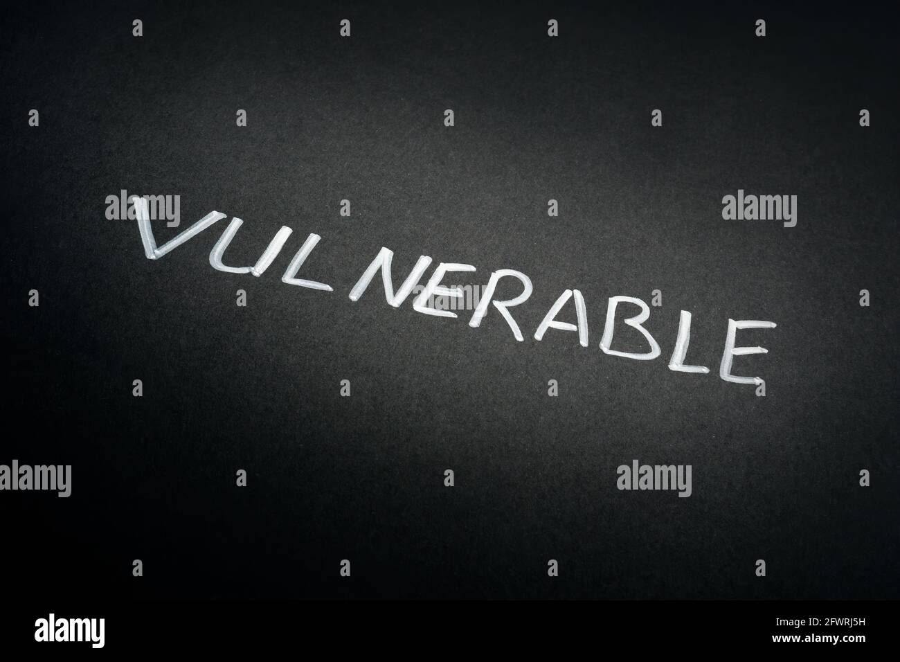 Handwritten word vulnerable on the dark paper Stock Photo - Alamy