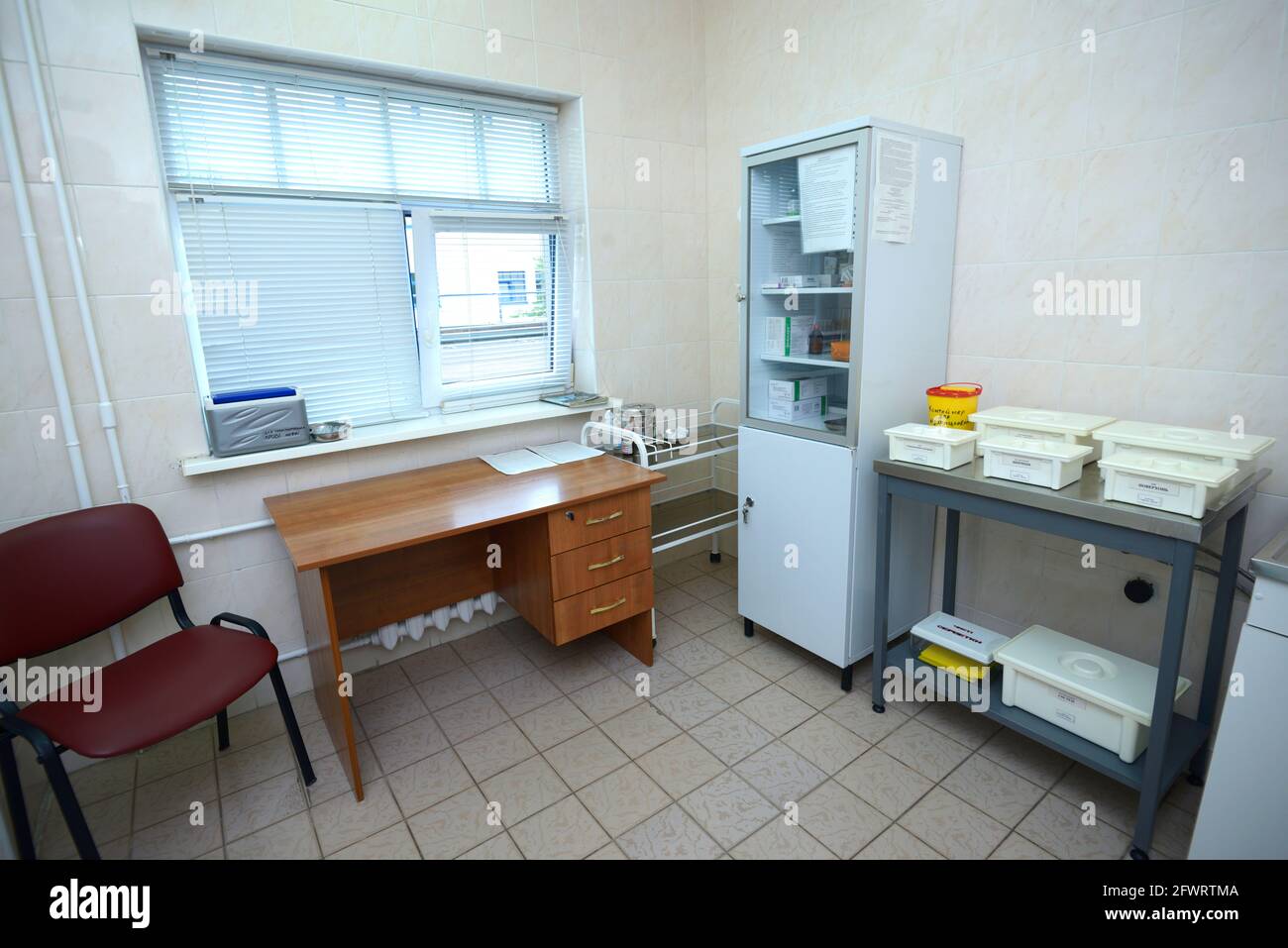 Interior of a nurse room: table, chair, fridge with drugs, containers ...