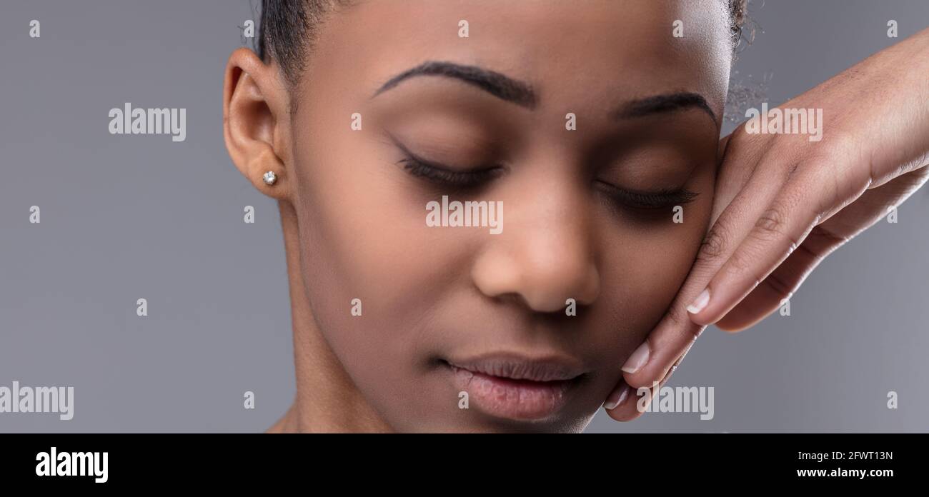 Sensual tender portrait of a young Black woman with downcast eyes being ...