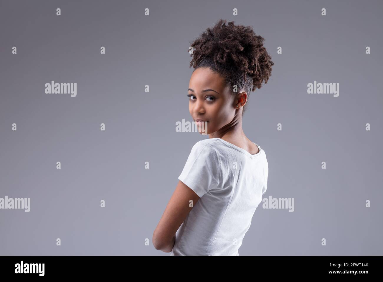 Attractive slim young Black woman looking back over her shoulder with ...