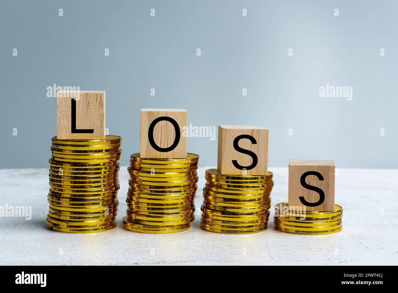 Loss text on wood block with a pile of gold coins Stock Photo - Alamy