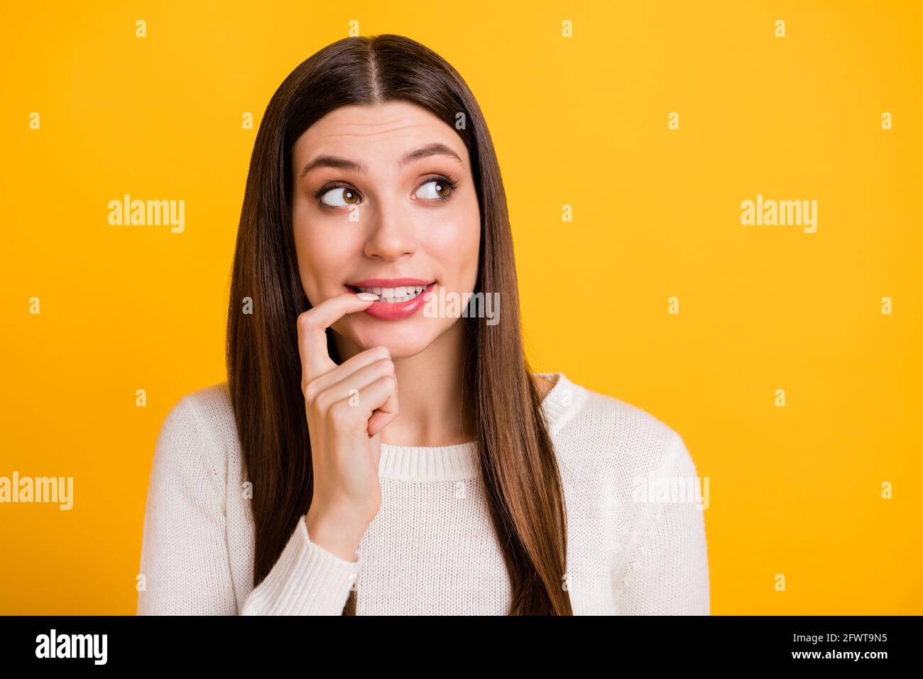 Photo of adorable positive person biting finger nail look empty space ...