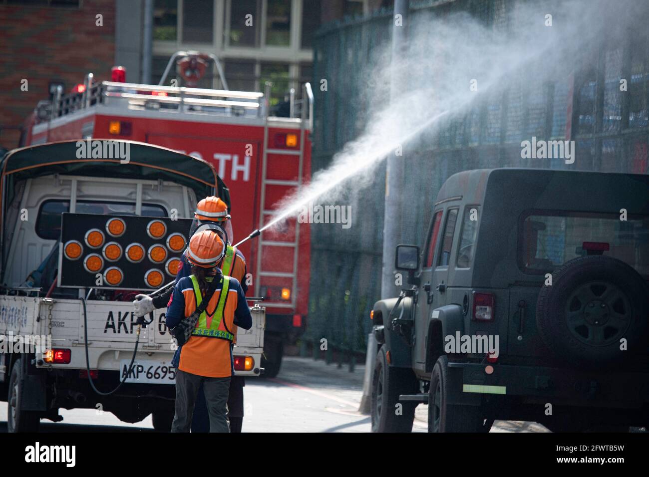 Workers from the Department of Environmental Protection (EPA) disinfect ...