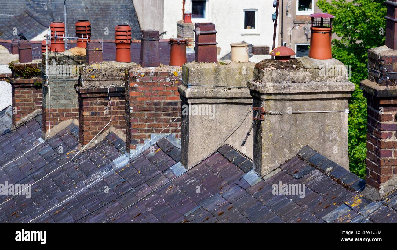 slate roof tops and chimneys stacks and pots on British terraced houses ...
