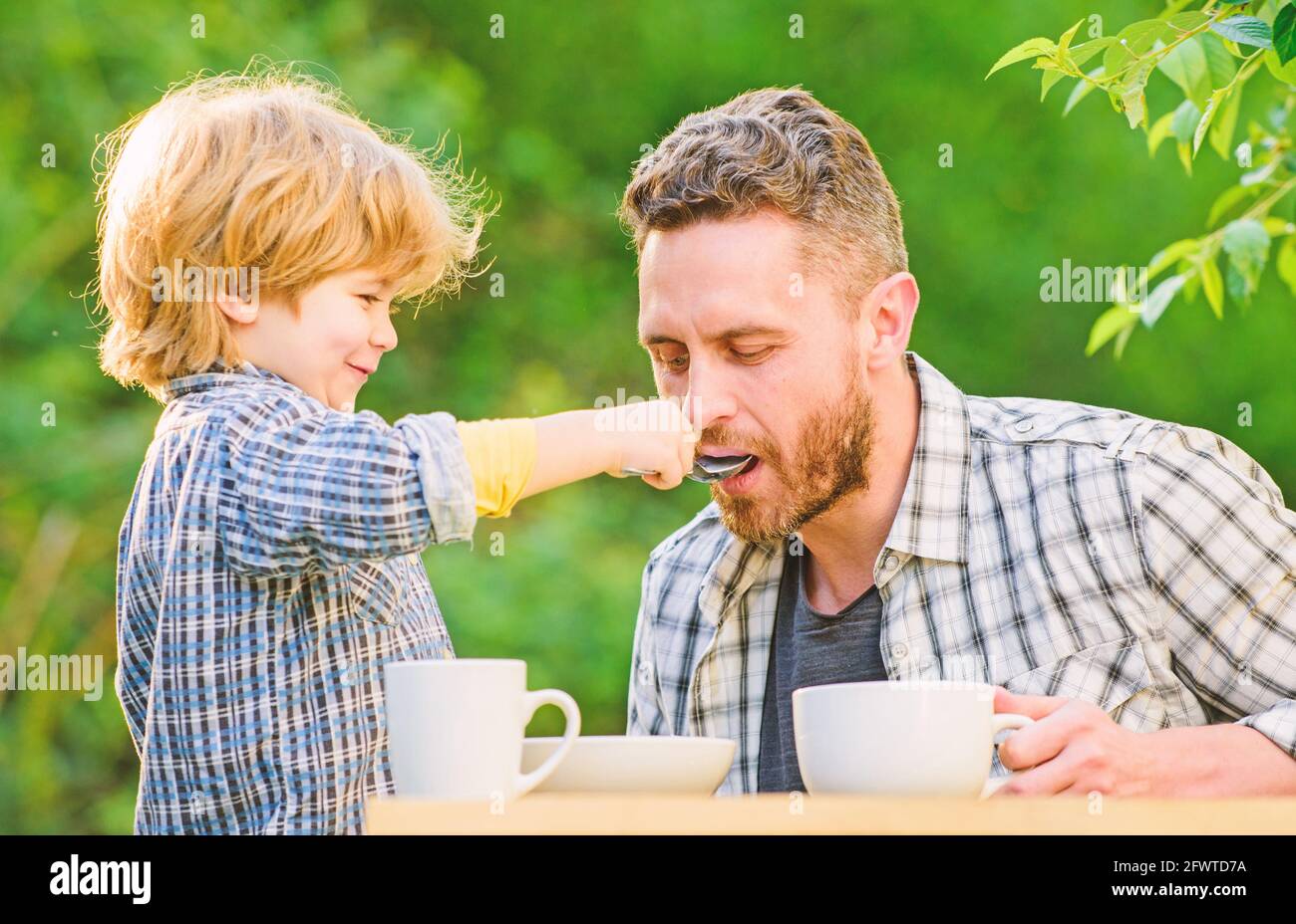 Dad and boy eat and feed each other outdoors. Ways to develop healthy ...