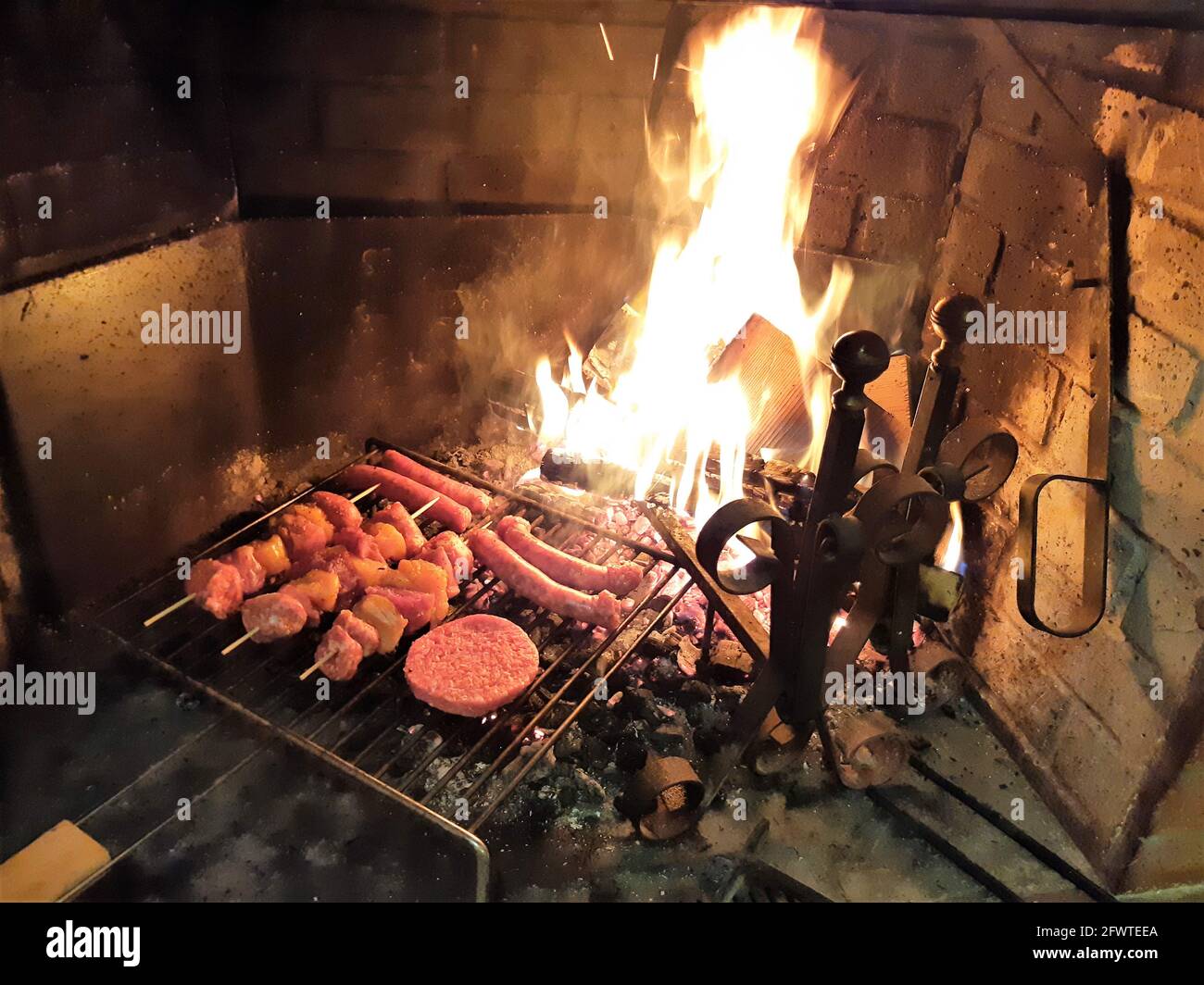 Mixed grilled meat in a lit fireplace Stock Photo - Alamy