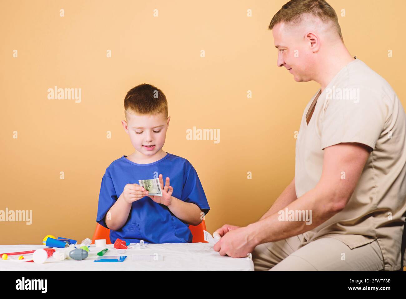 Kid little doctor sit table medical tools. Health care. Medical ...