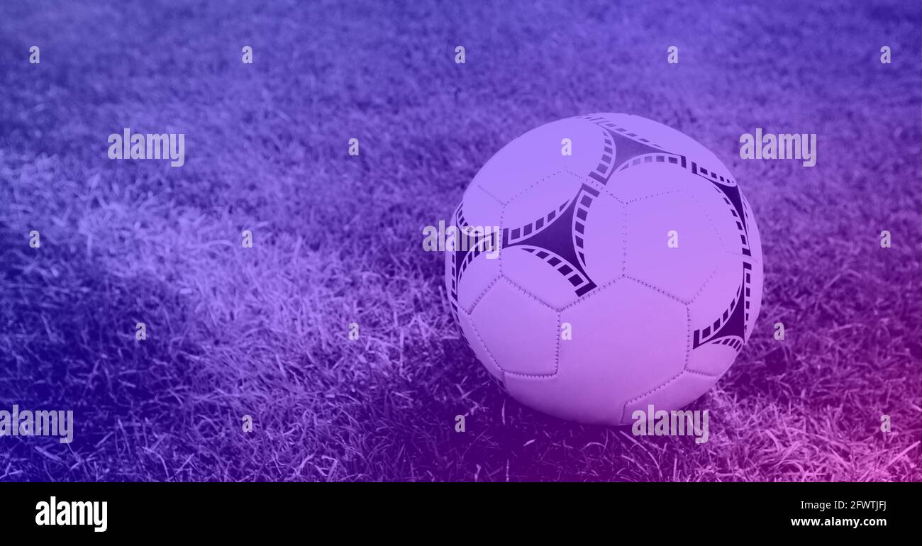 Composition of football lying on stadium over purple blur Stock Photo ...