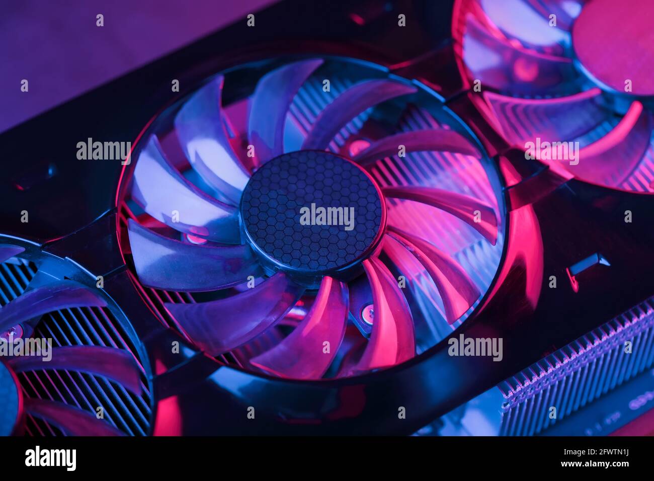 A close-up video card fan with cyanide magenta illumination in a ...
