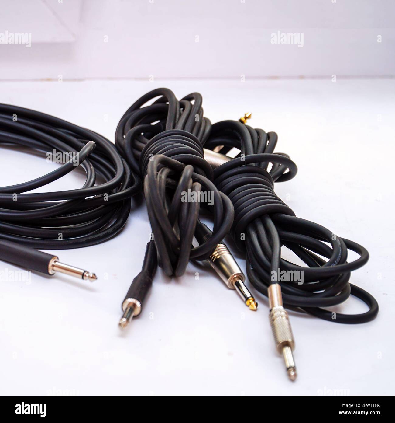 Audio cables for musical instruments and microphones on a white ...