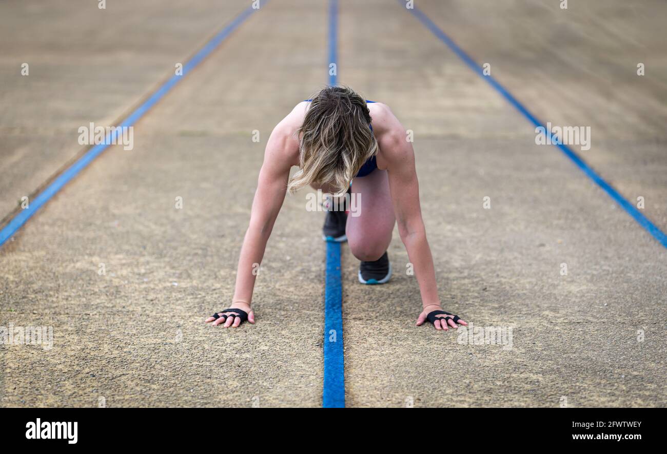 Strong woman in start position for a sprint on a runners track Stock ...