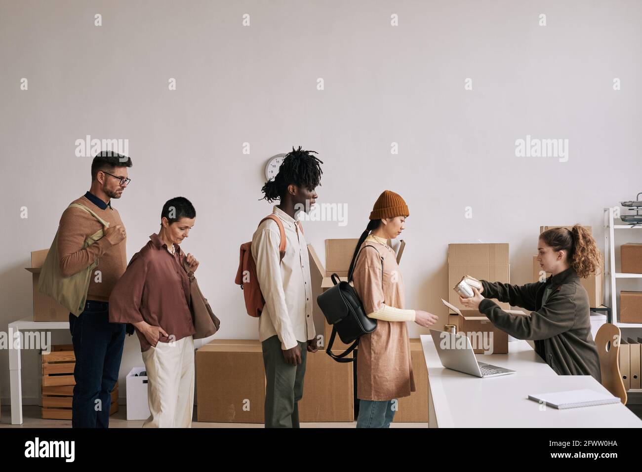 Side view at diverse group of people standing in line during help and ...