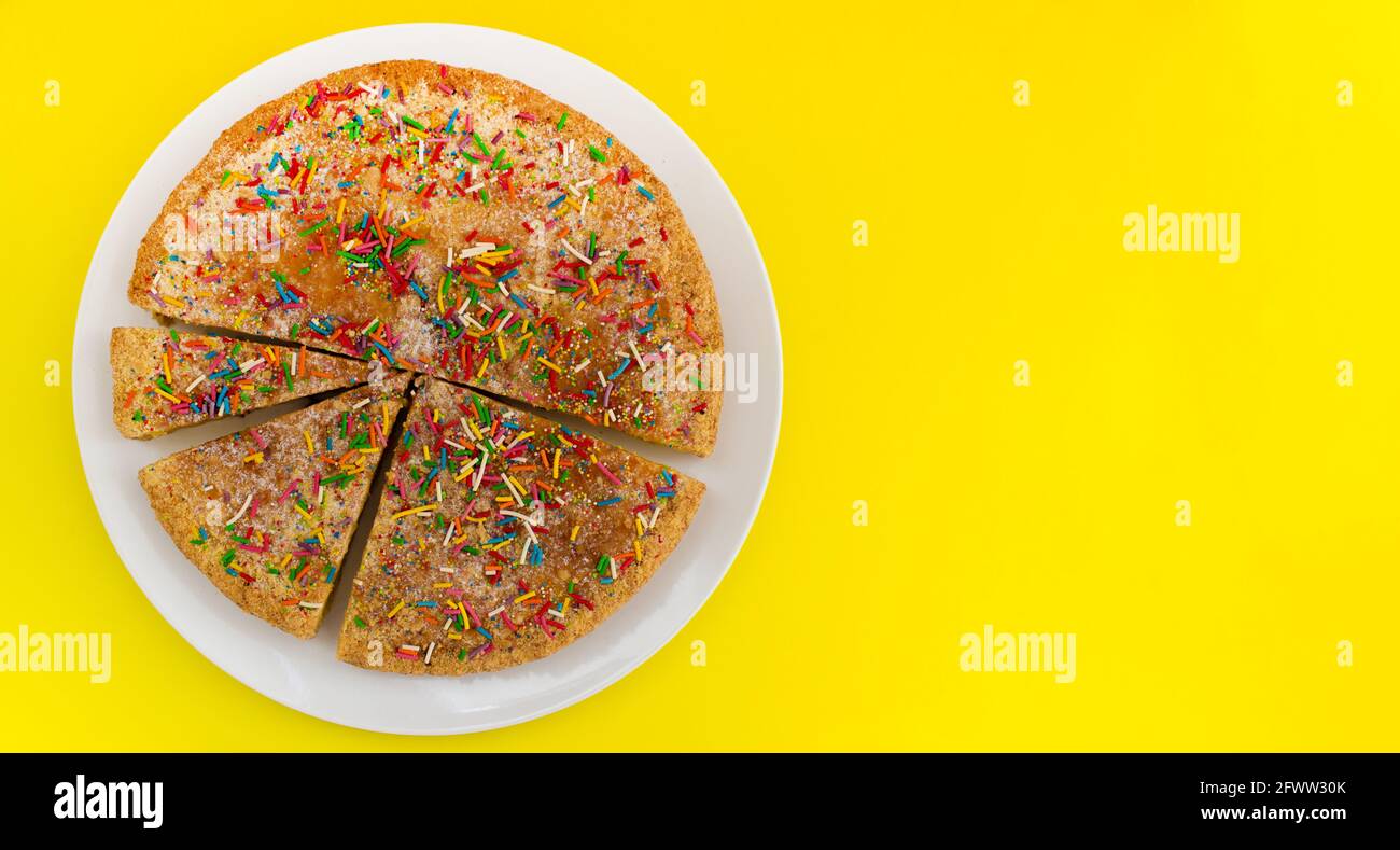 flat cake with colored sprinkles on yellow background, top view Stock ...