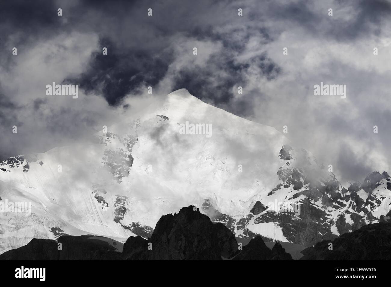 Black and white high snowy mountains with glacier, rocks and sky with ...