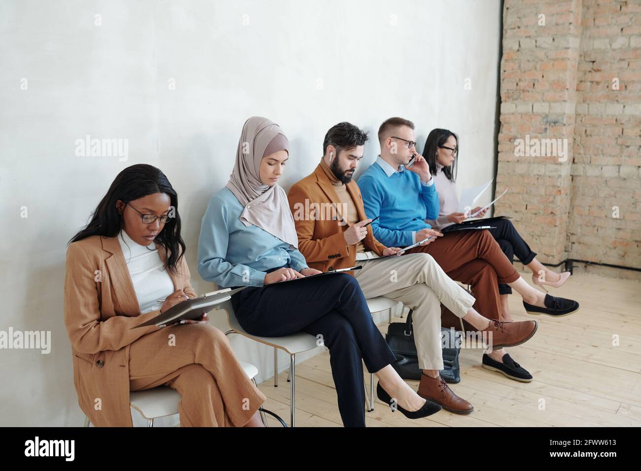 Group of serious young multi-ethnic job candidates in stylish outfits ...