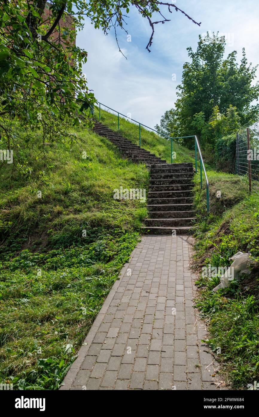 tourism pathway in the summer green park with gravel, wooden rails and ...