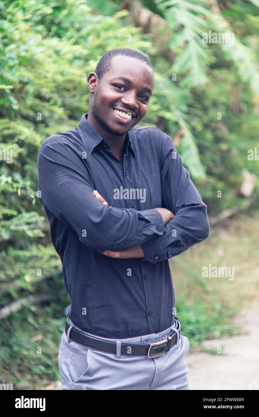 A charming, friendly african man who stands smiling and shows sincere ...